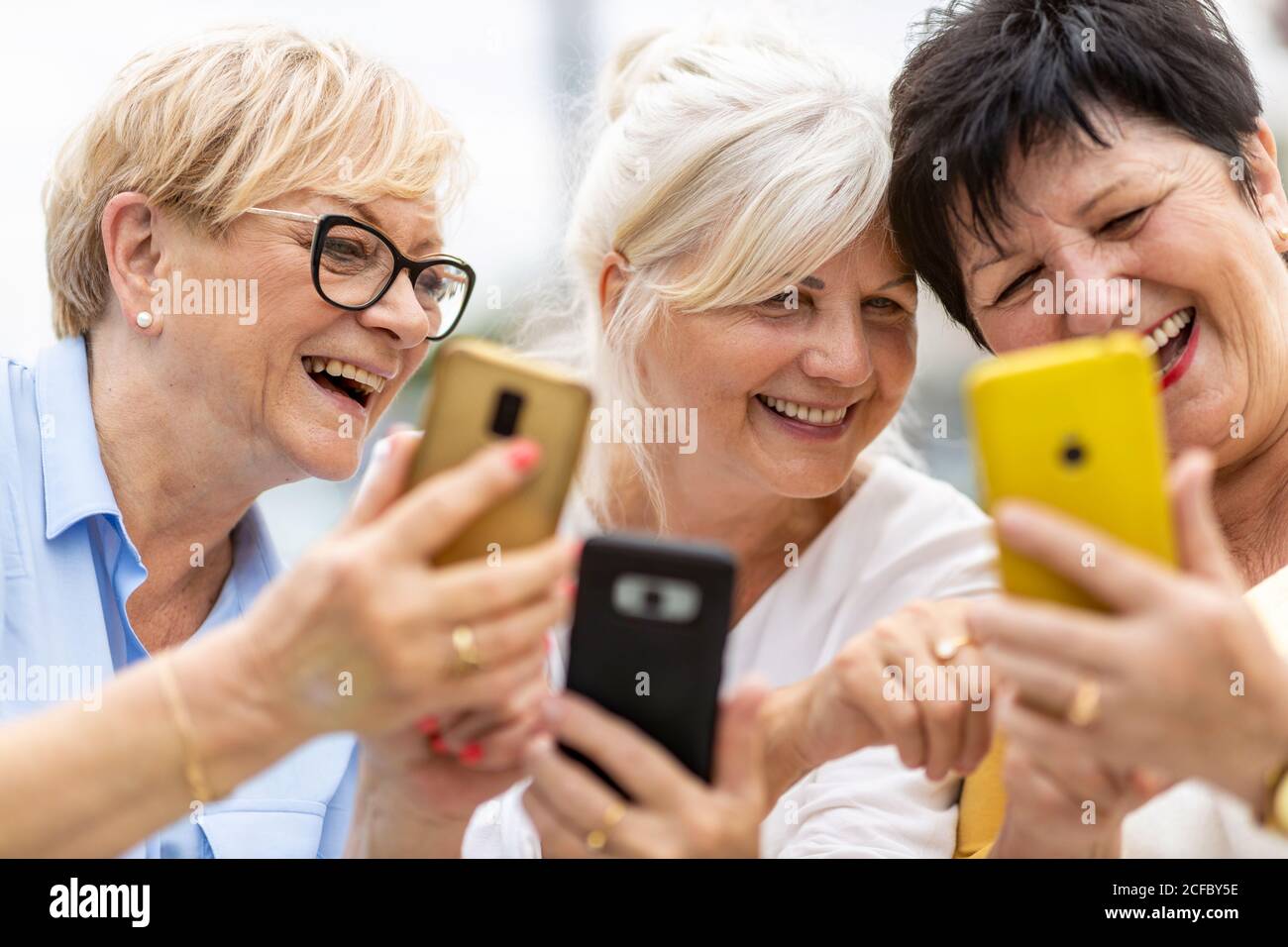 Group of senior women using smartphones together Stock Photo - Alamy