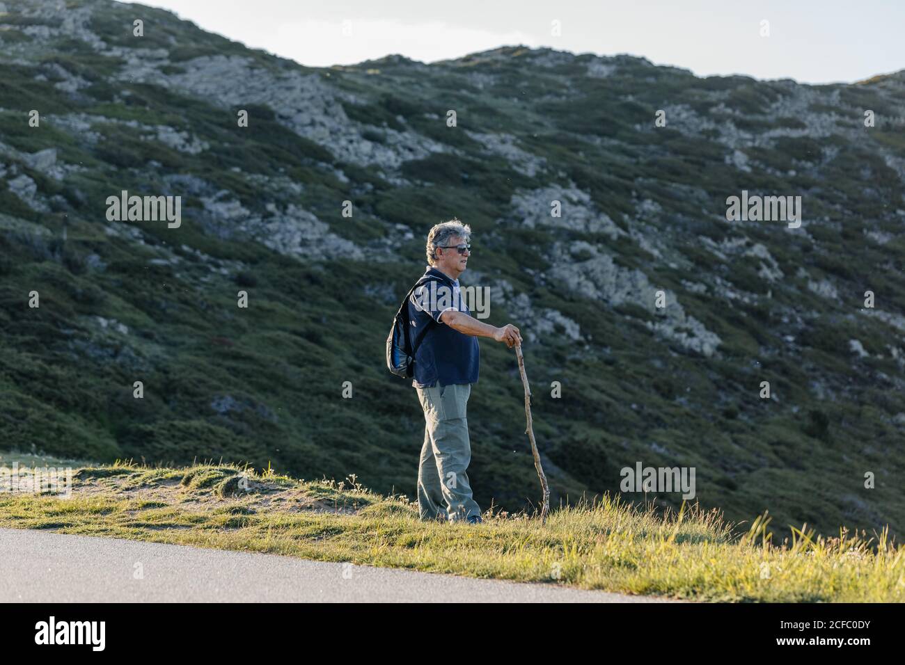 Side view of a senior man hiking through the mountain Stock Photo - Alamy