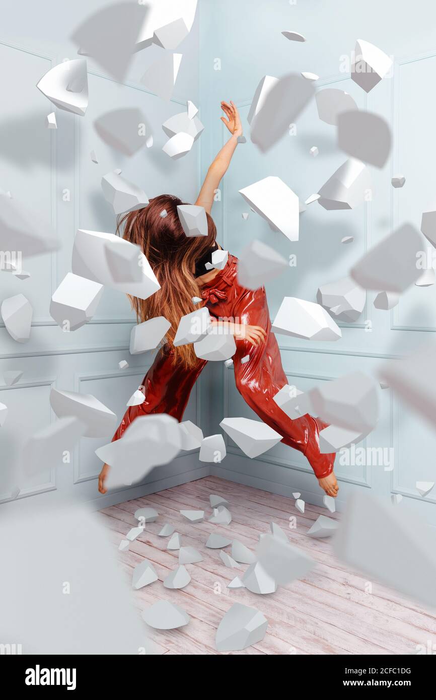 Full body anonymous energetic Woman in stylish outfit jumping in corner ...