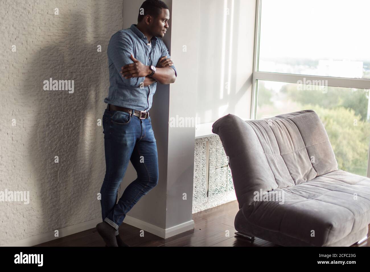 African leaned against the wall in his house Stock Photo - Alamy
