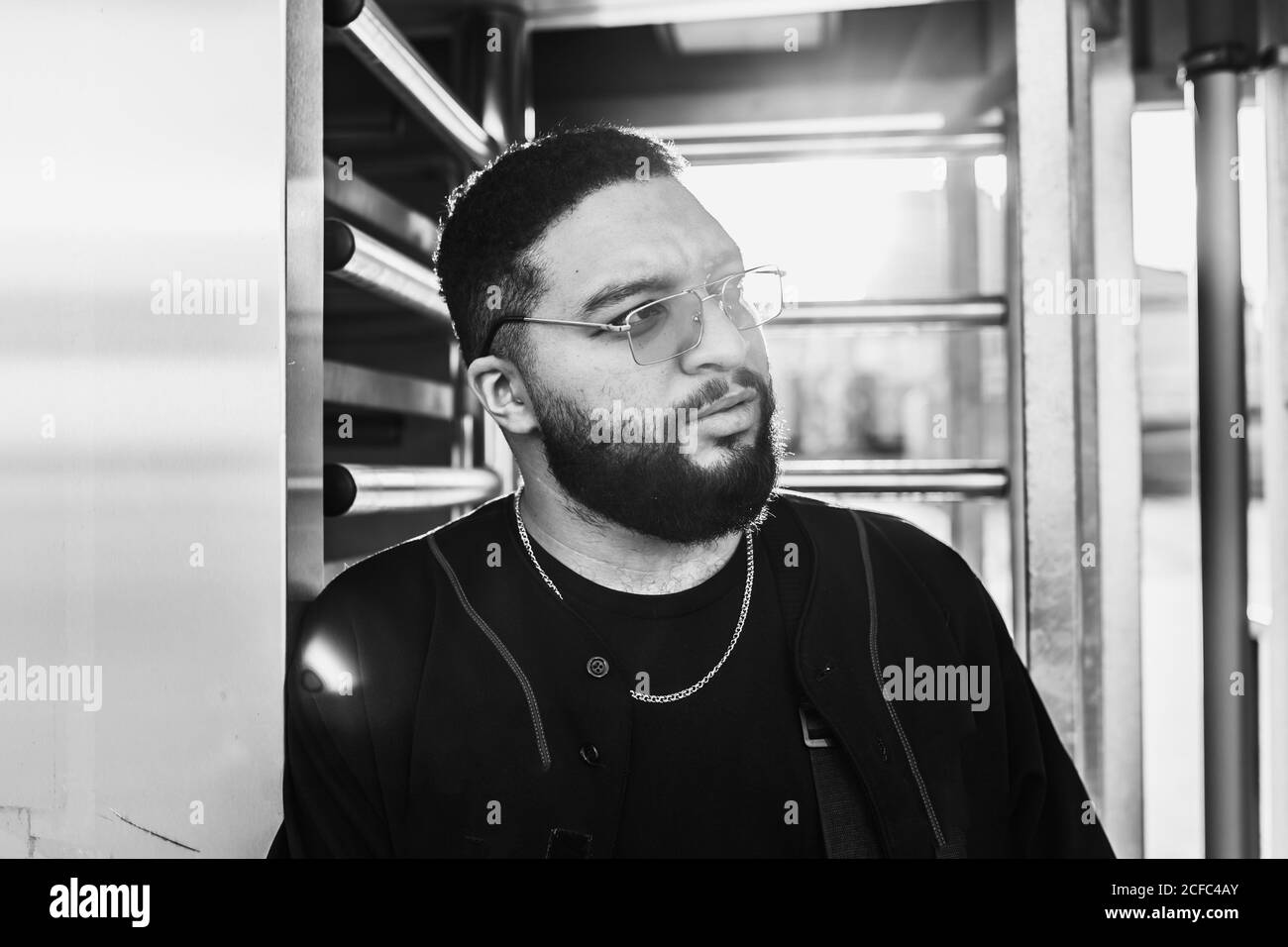 black and white portrait of a man in the backlight near the turnstile ...