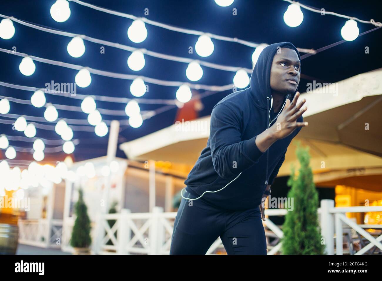 Young sportsman jogging in the night city Stock Photo - Alamy