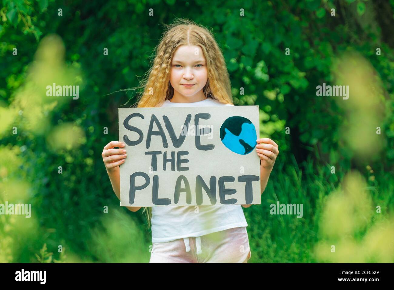 child girl activist with save the planet poster in forest park. preteen ...