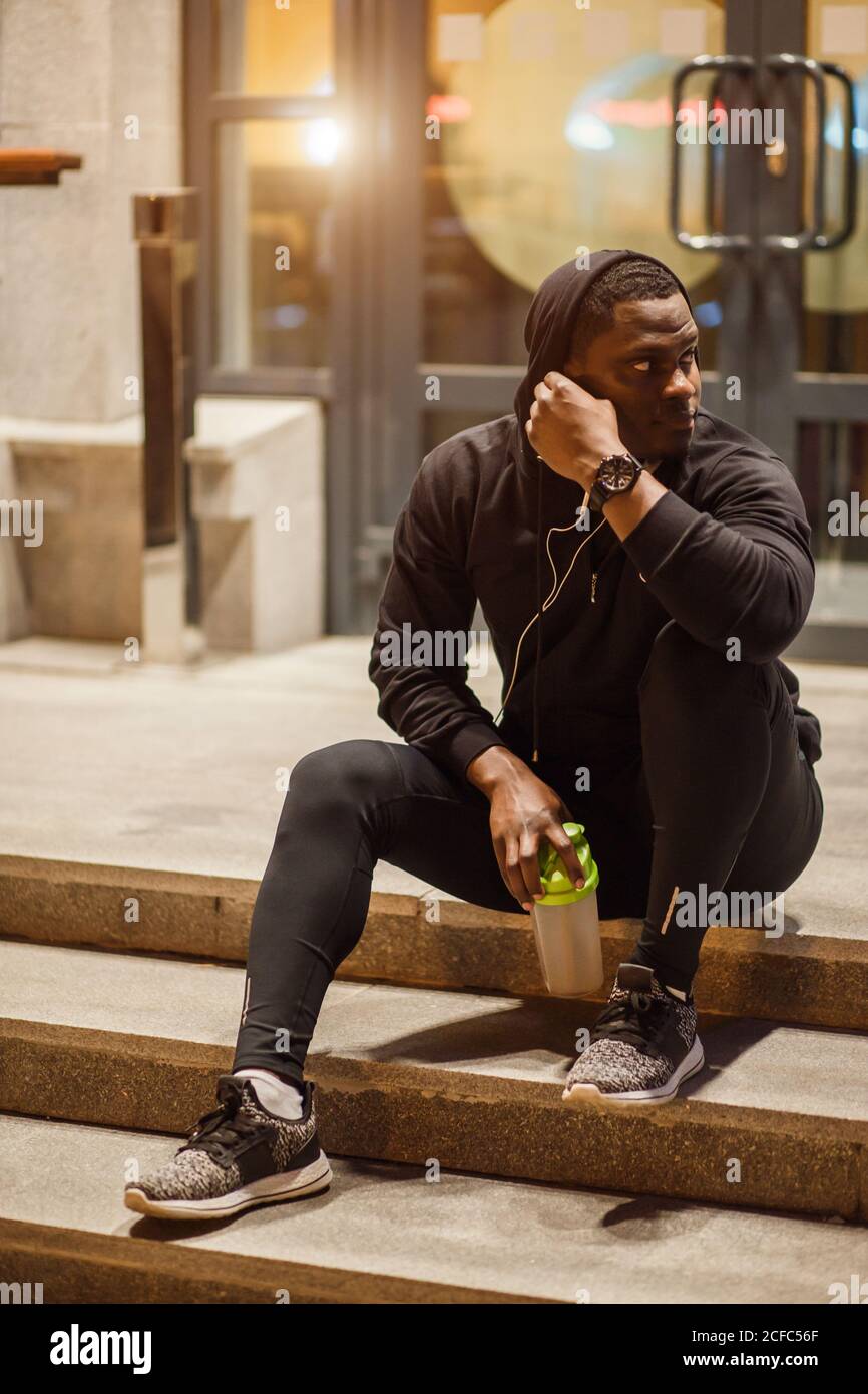 young man sitting on the ground at night, runner in break Stock Photo ...