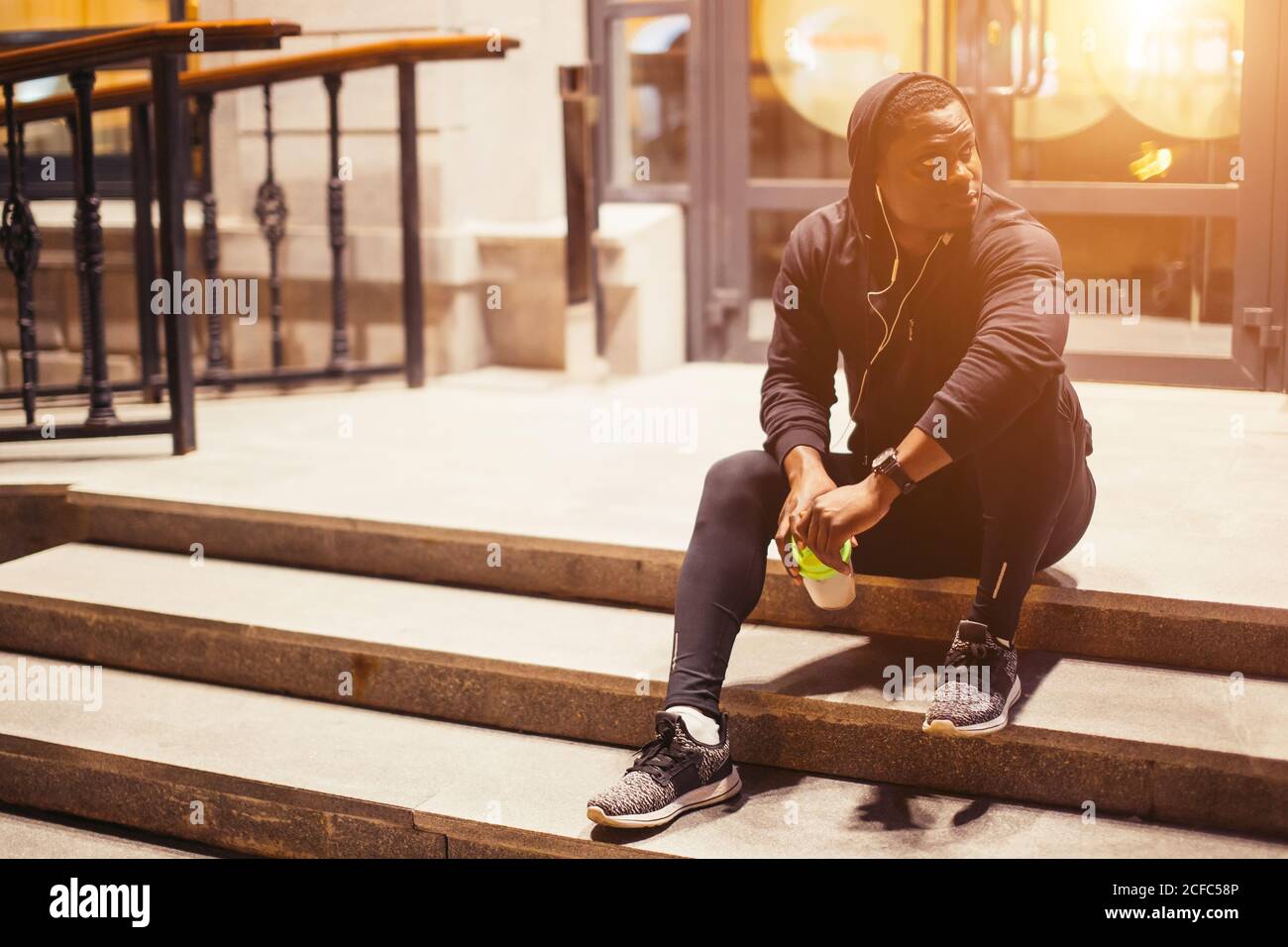 young man sitting on the ground at night, runner in break Stock Photo ...