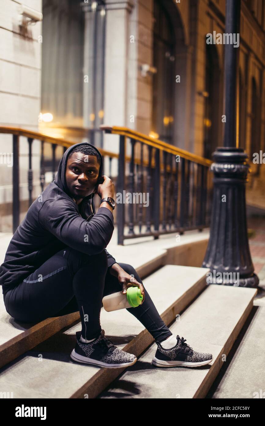young man sitting on the ground at night, runner in break Stock Photo ...