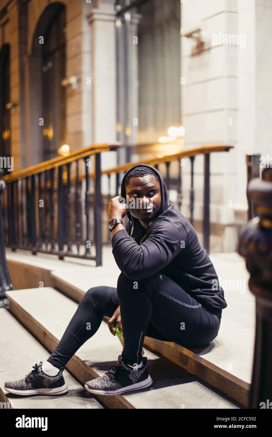 young man sitting on the ground at night, runner in break Stock Photo ...