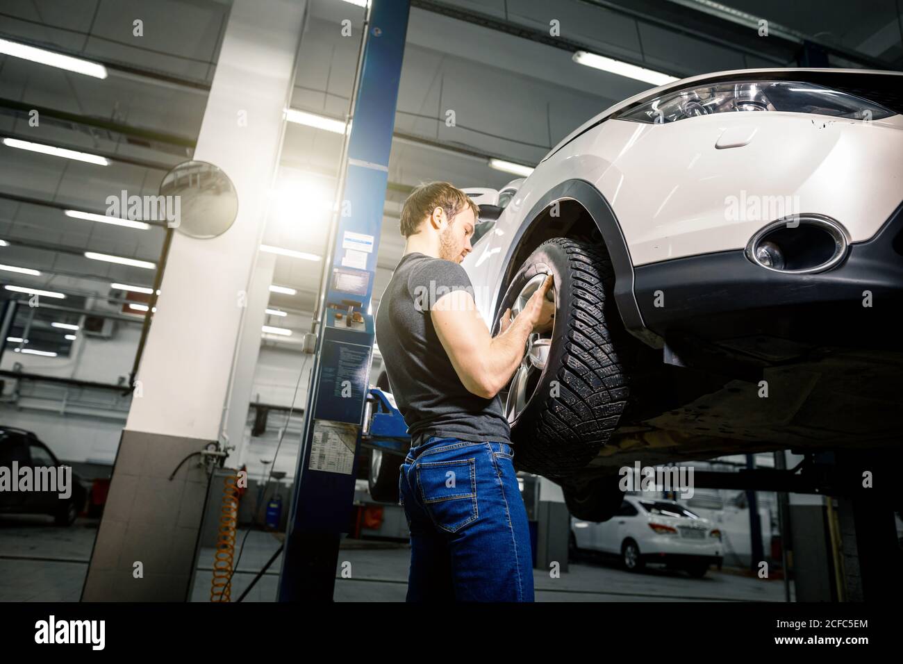 Mechanic adjusting tire wheel hi-res stock photography and images - Alamy