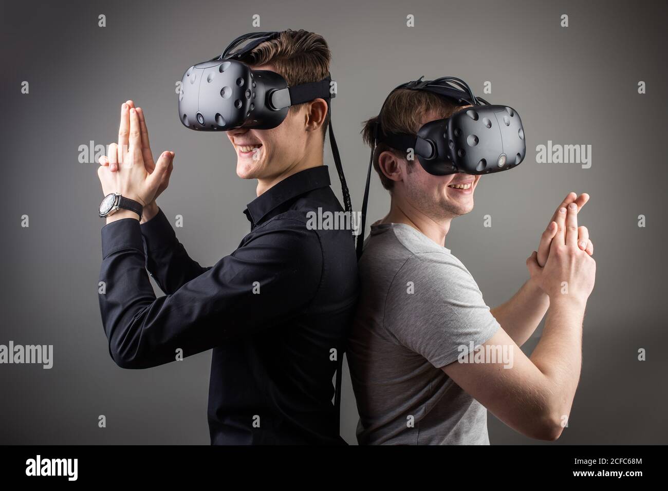Shot of two young man standing with VR goggles and keep joysticks or ...