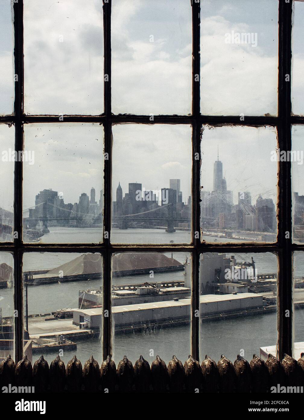 View through aged window on warehouse and Brooklyn Bridge across East ...