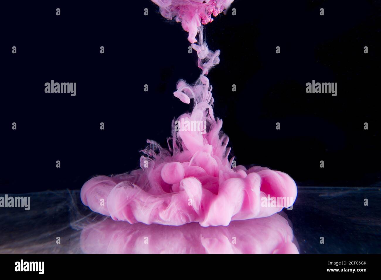 Abstract paint pink splash drip up in water Stock Photo - Alamy