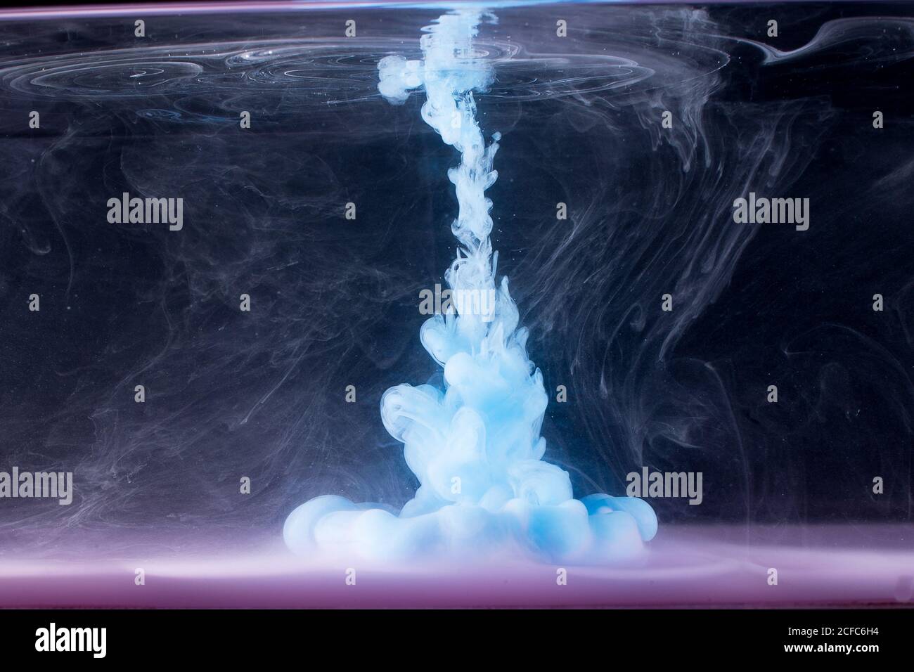blue color paint pouring in water on dark background Stock Photo - Alamy