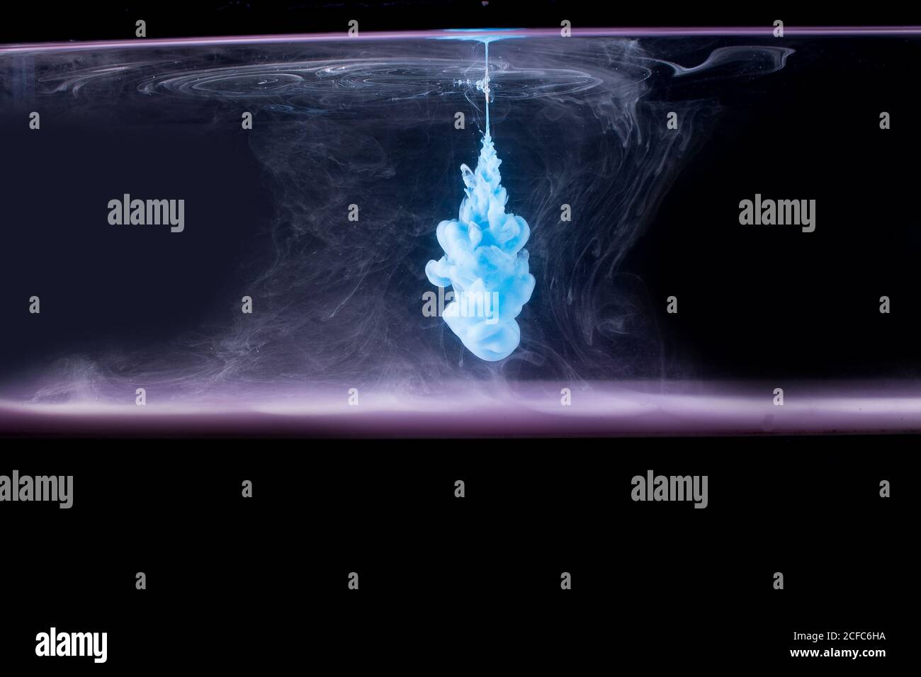 blue color paint pouring in water on dark background Stock Photo - Alamy
