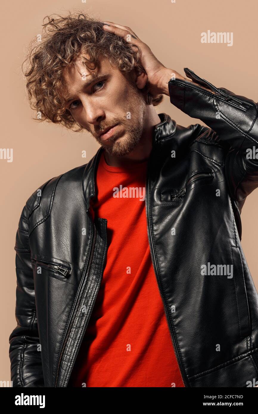 Freestyle. Man with curly hair in laser jacket standing isolated on ...