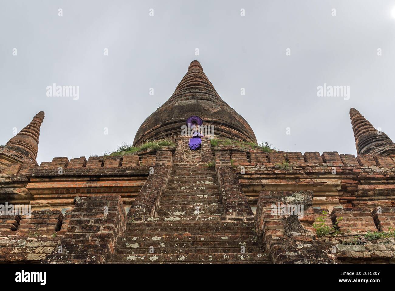 From below of ancient Burmese stone temple in Bagan against grey cloudy ...