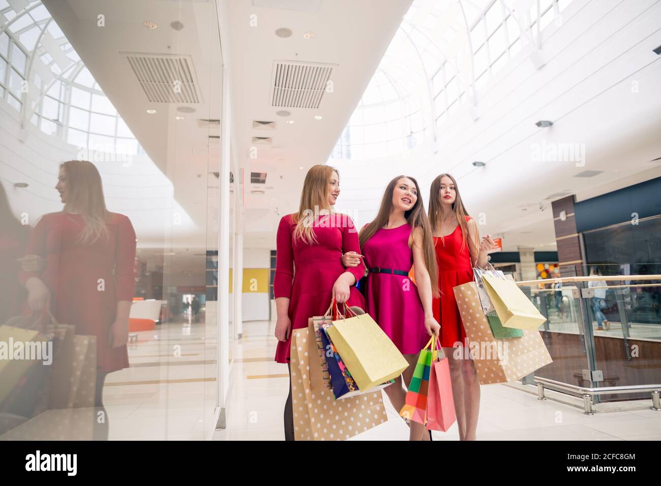 Beautiful girls with shopping bags walking at the mall Stock Photo - Alamy