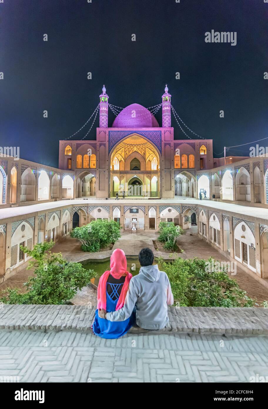 Back view of young Muslim couple sitting in courtyard of beautiful ...