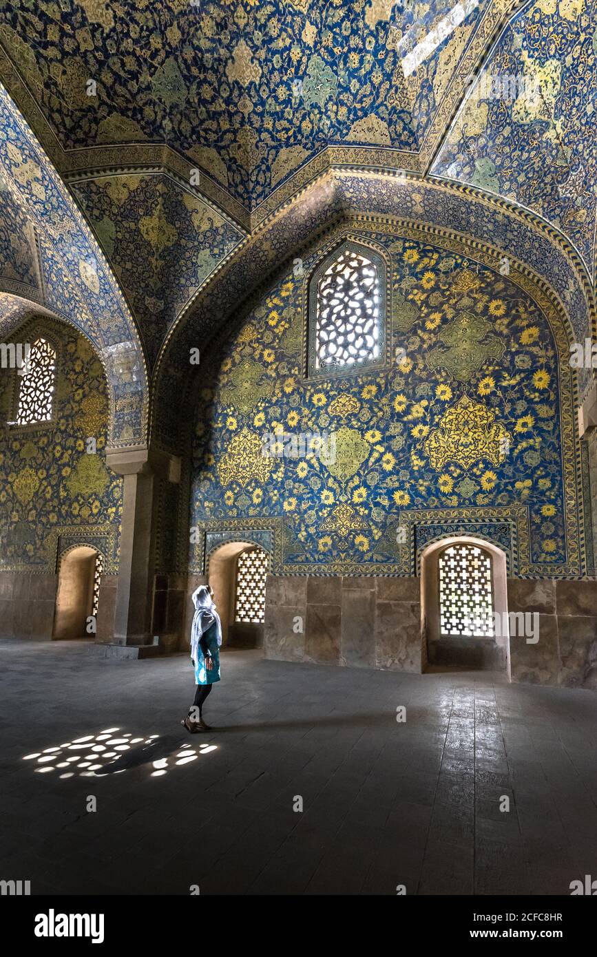 Side view of Muslim female standing in majestic Iranian mosque with ...