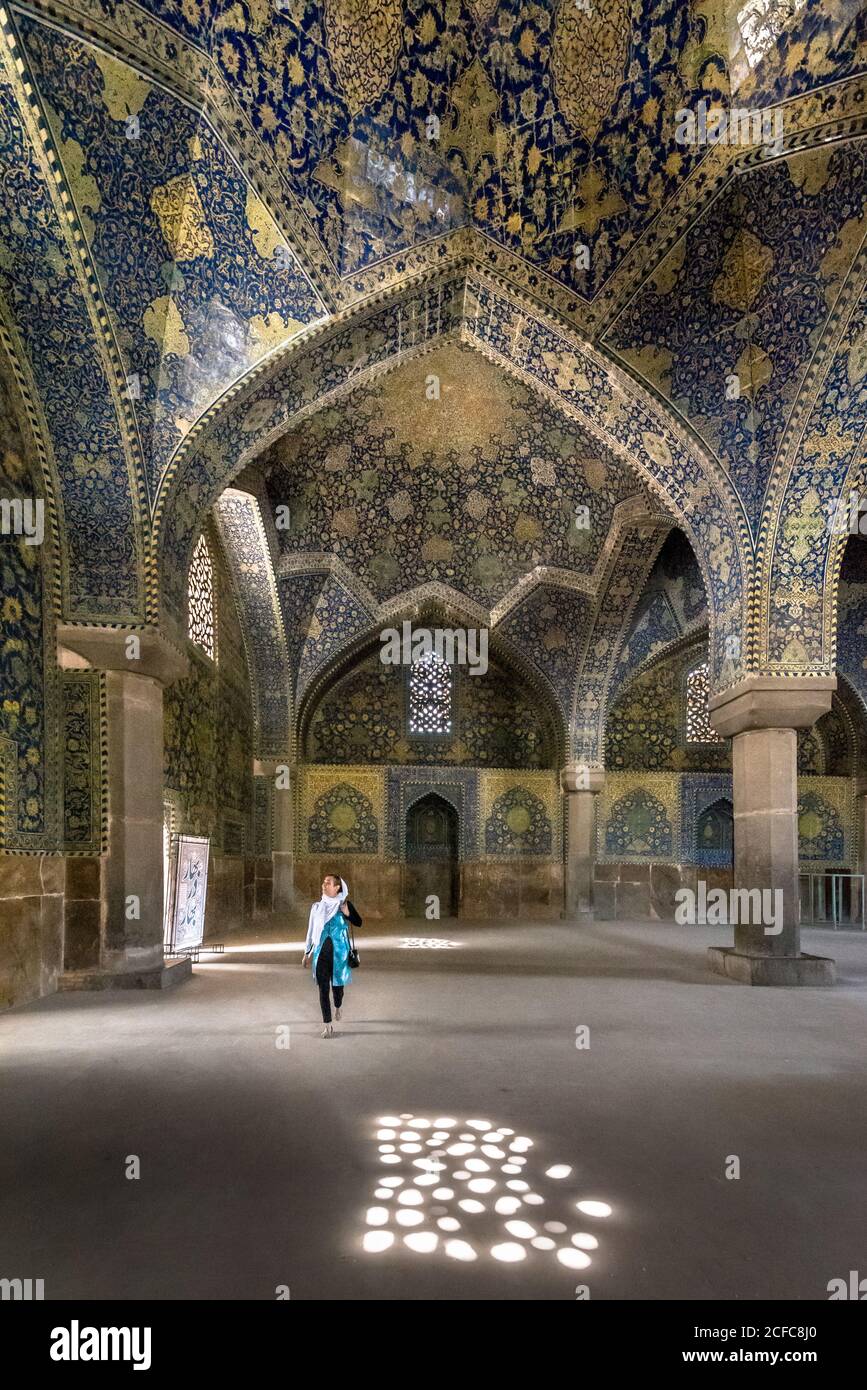 Muslim female standing in majestic Iranian mosque with ornamental walls ...