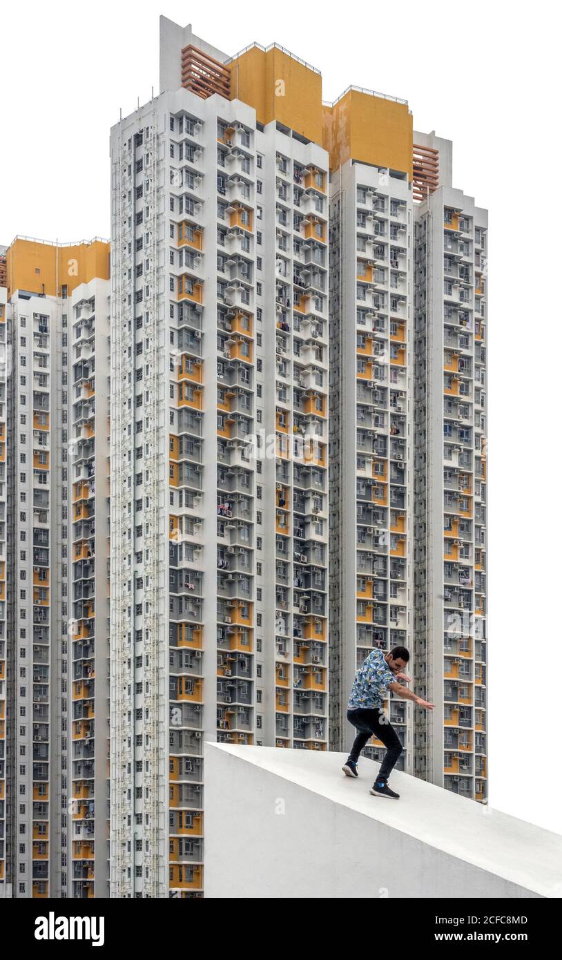 Faceless relaxed male in casual clothes pretending to surf on concrete ...