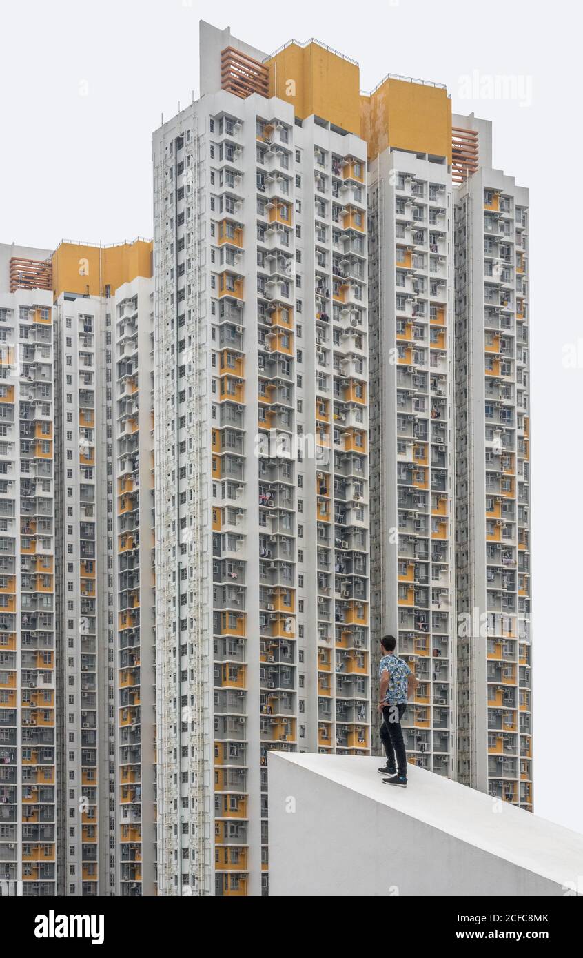 Relaxed male in casual clothes posing on concrete sloping roof looking ...
