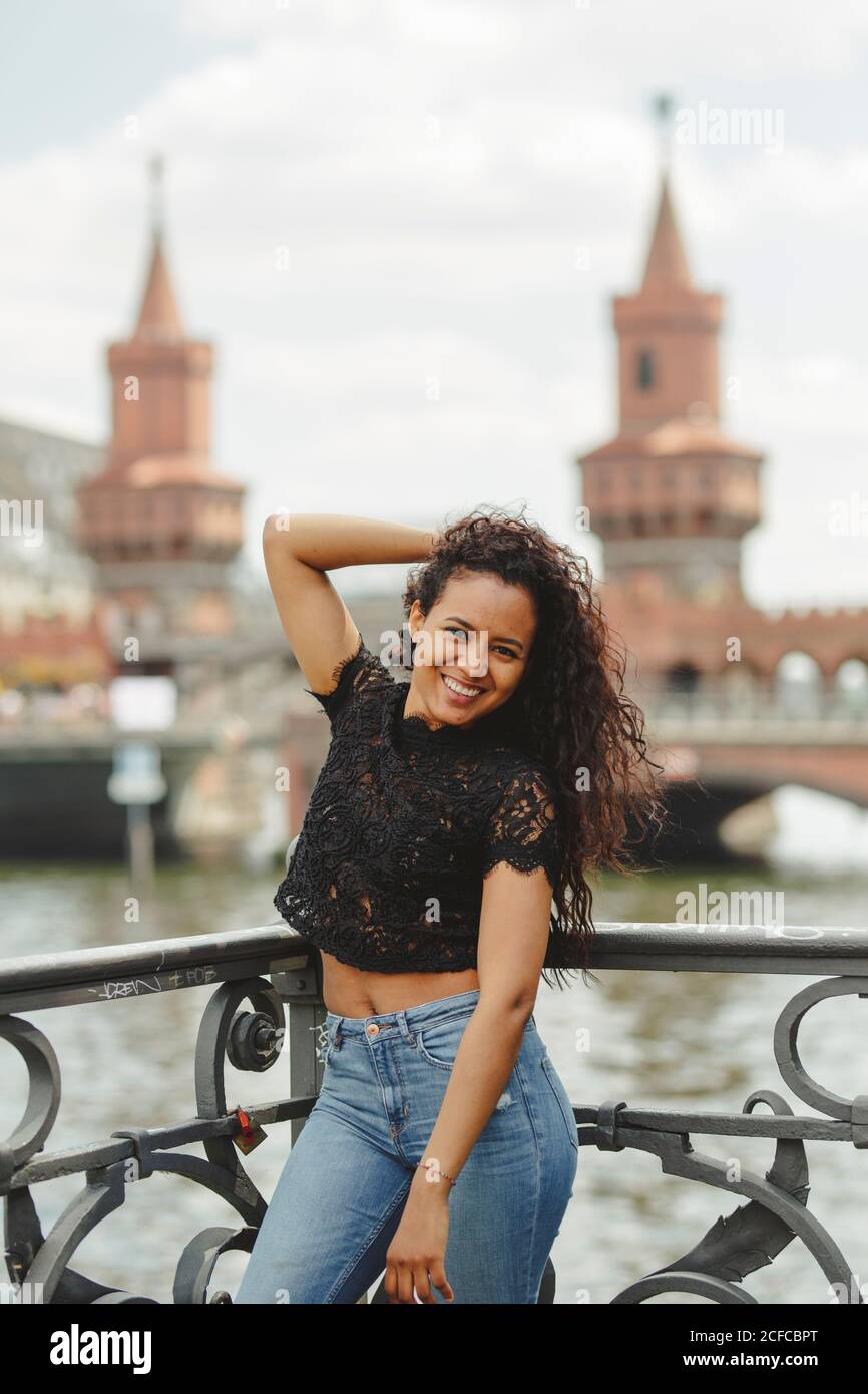 Beautiful ethnic female model leaning on railing on summer day in ...