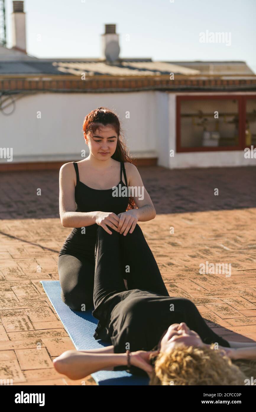 Women practicing partner yoga on rooftop Stock Photo - Alamy