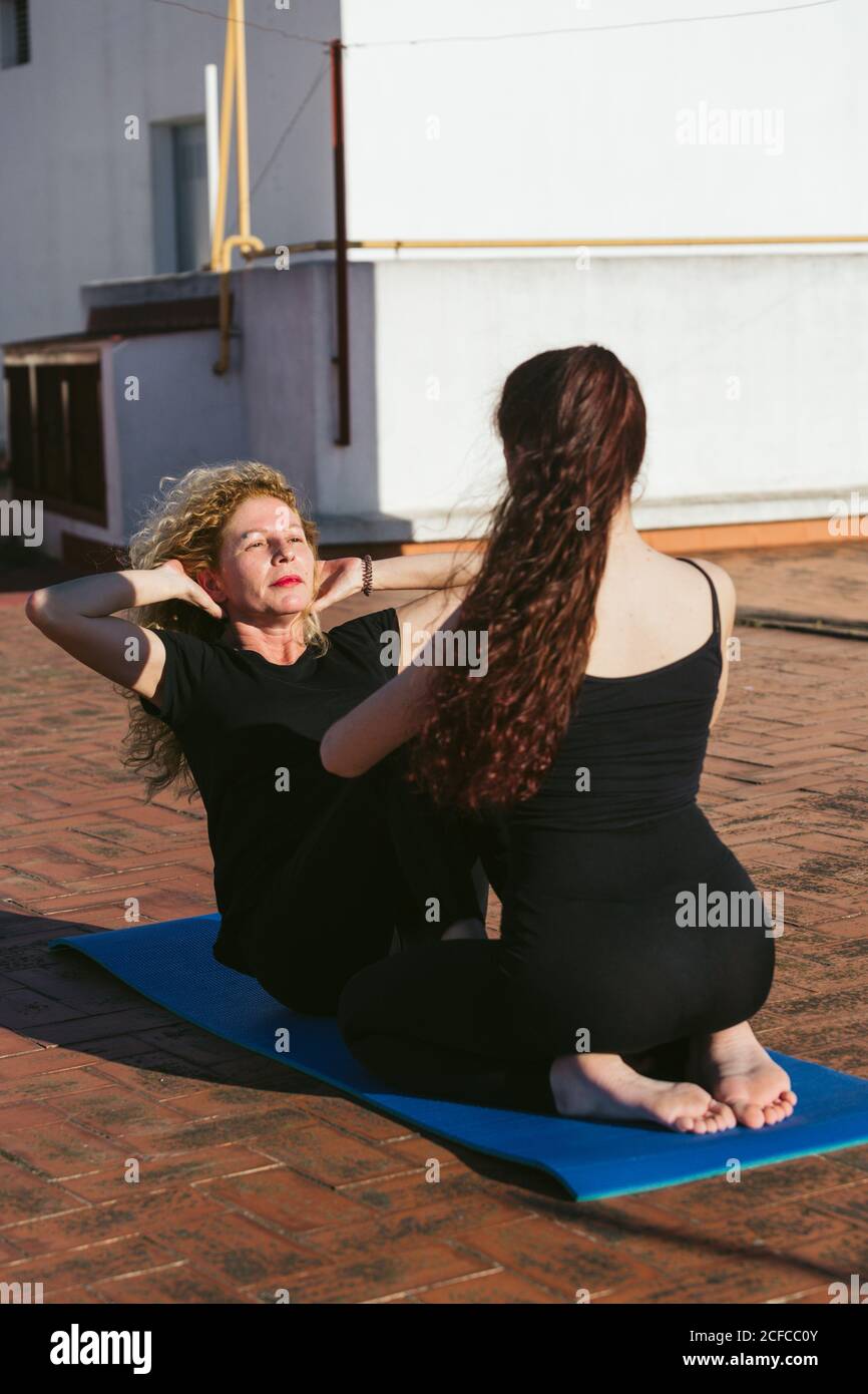 Women practicing partner yoga on rooftop Stock Photo - Alamy