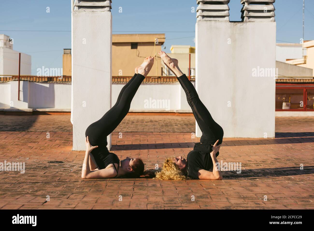 Side view of young female with mature mother doing Supported Shoulder ...