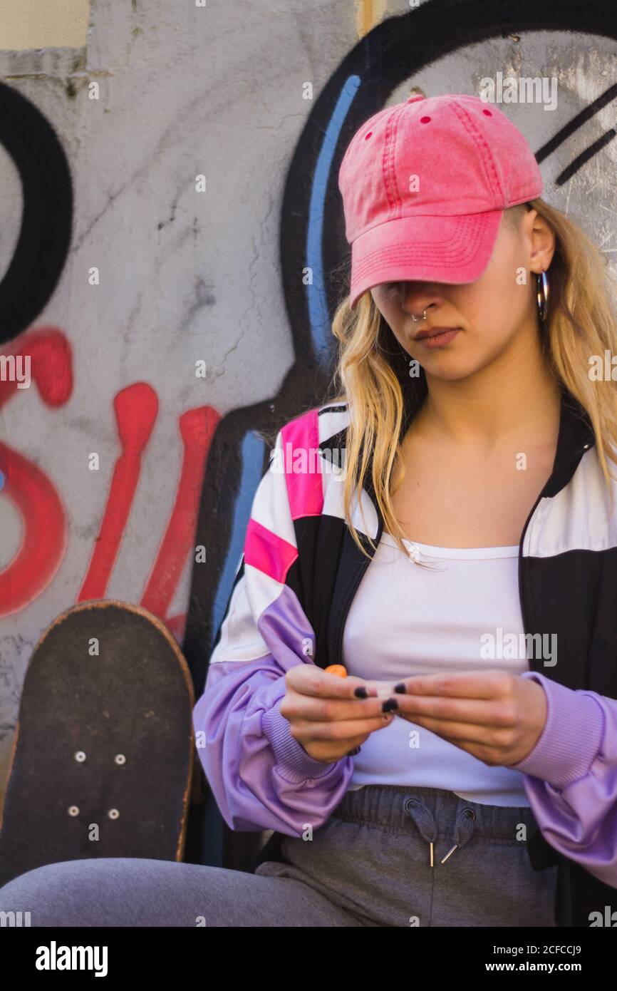 Rebellious female millennial standing near girlfriend with skateboard ...