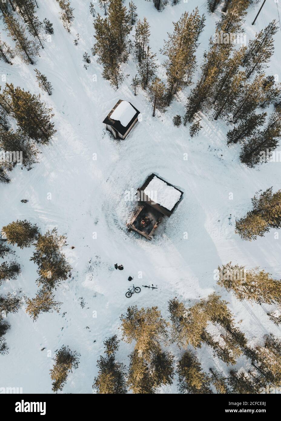 Aerial top view of small lumberjack cabins located among snowy pine ...