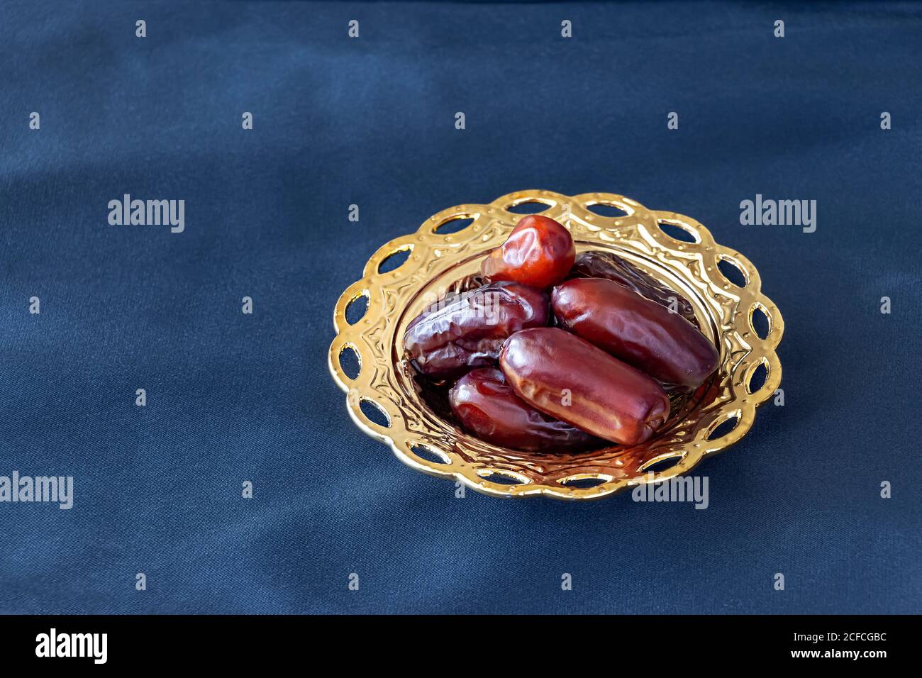 Organic dried dates in traditional arabic golden plate. Iftar Holy ...