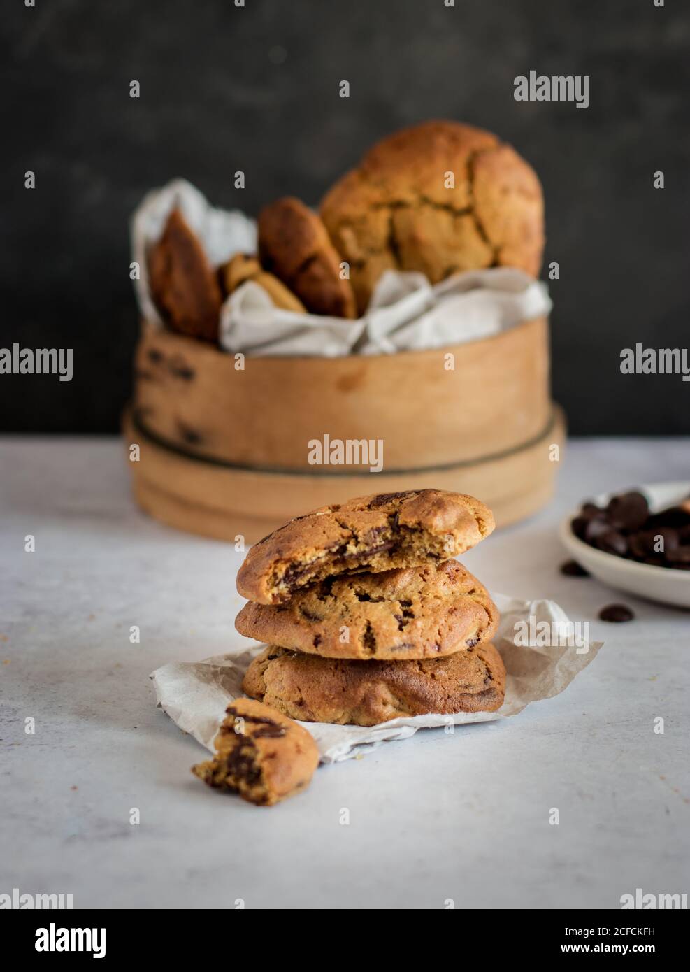 Stack of yummy chocolate chip cookies with bitten piece placed on table ...