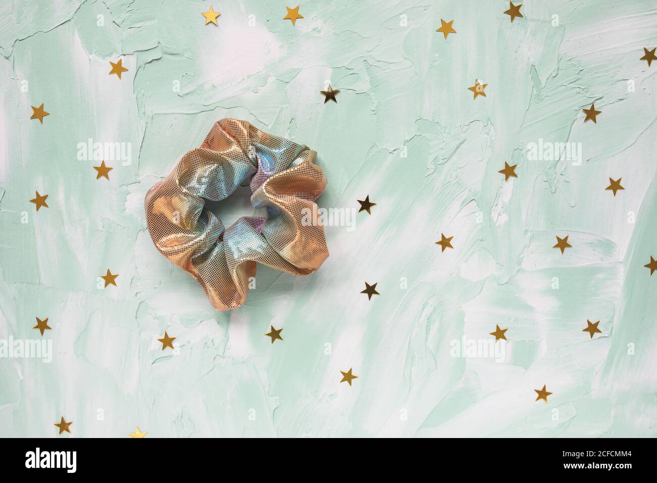 Trendy holographic scrunchie and stars on green Stock Photo - Alamy