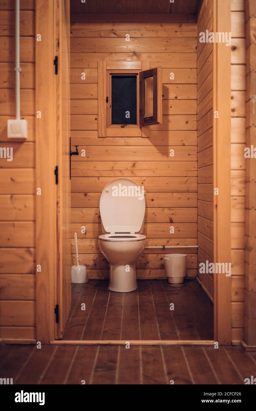 Bathroom in wooden house with opened door Stock Photo - Alamy