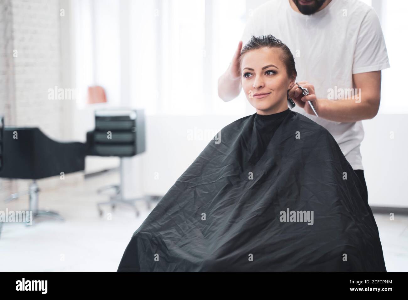 Hairdresser cuts Woman's hair with scissors Stock Photo - Alamy