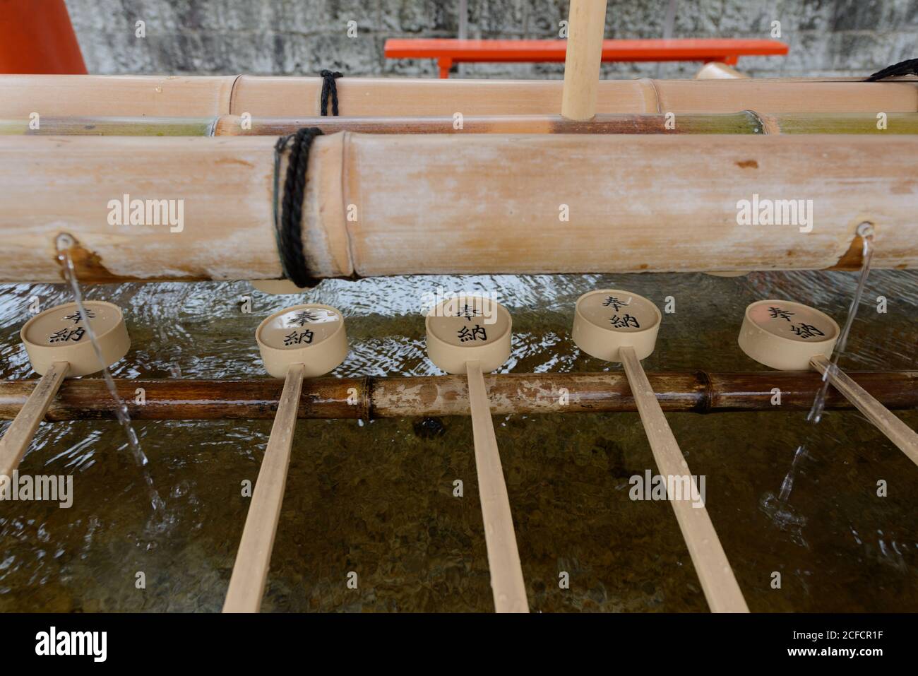 Wooden dippers and basin with water for cleaning ritual at entrance of ...