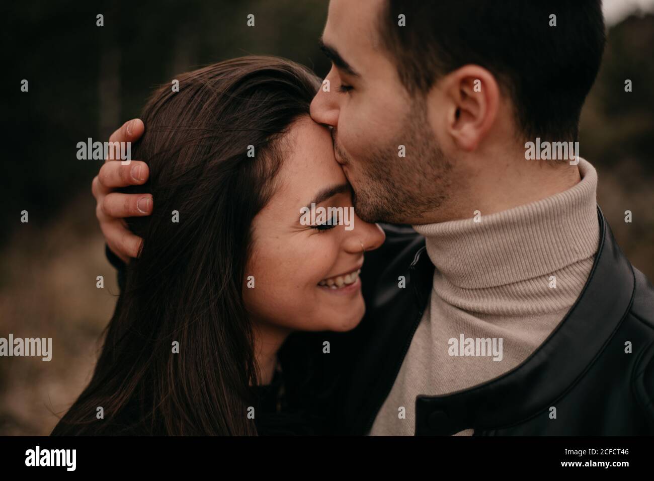 Side view of couple in love with closed eyes smiling while embracing ...