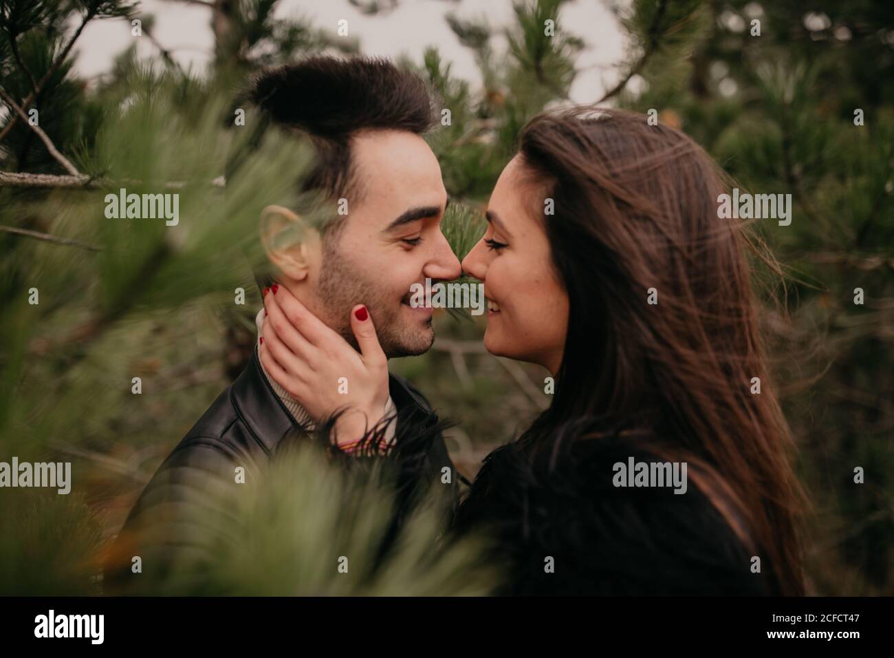 Side view of couple in love with closed eyes smiling while embracing ...
