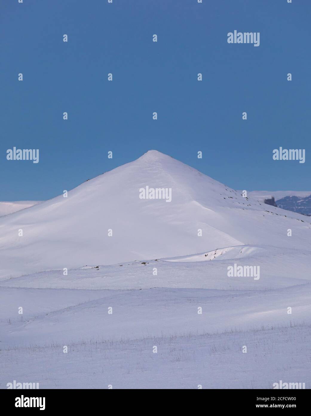 Minimalist winter landscape with snowy hill and valley under clear blue ...