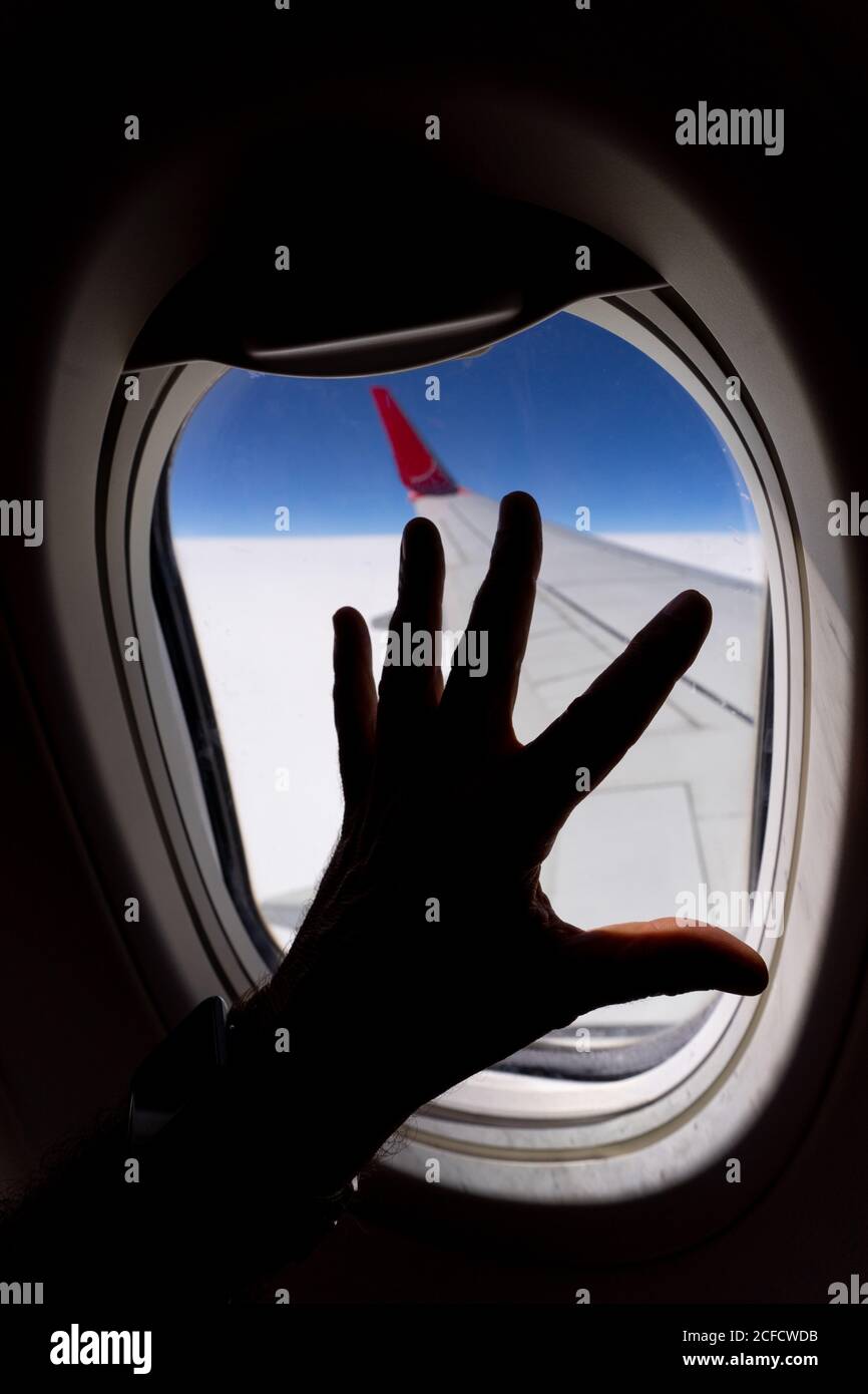 From above of faceless passenger waving during flight in aircraft ...