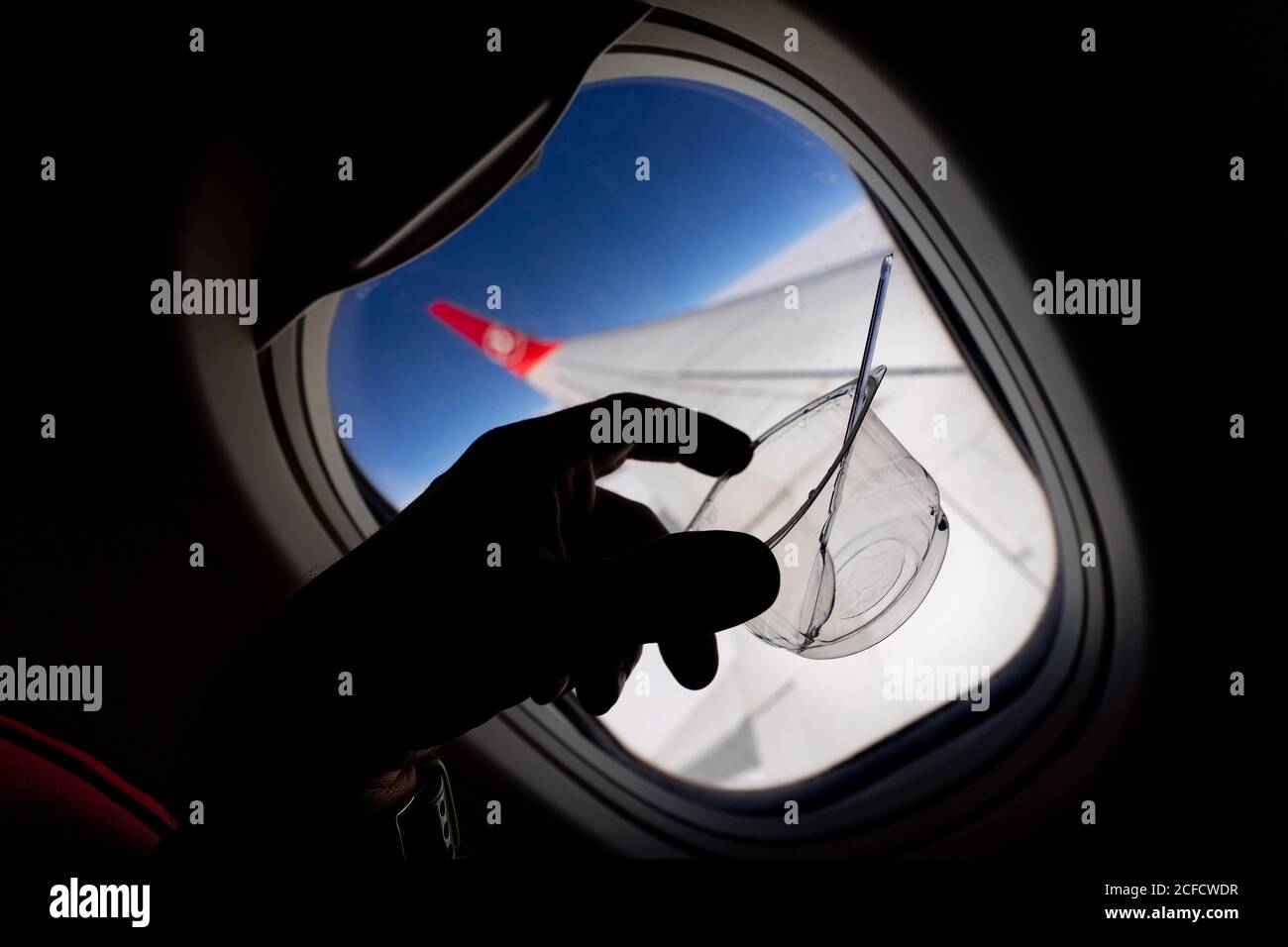 Crop passenger with plastic glass during flight in plane Stock Photo ...