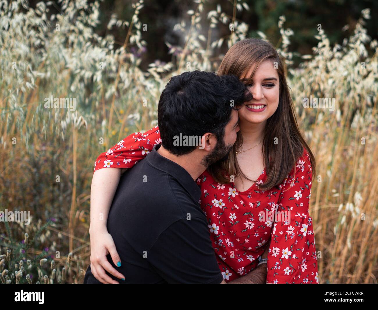 man hugging tenderly smiling pregnant wife sitting on his lap on ...