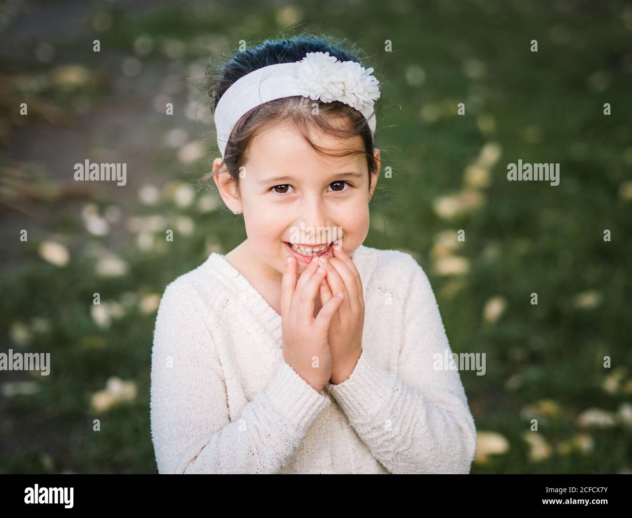 Portrait of adorable happy female kid looking at camera on background ...
