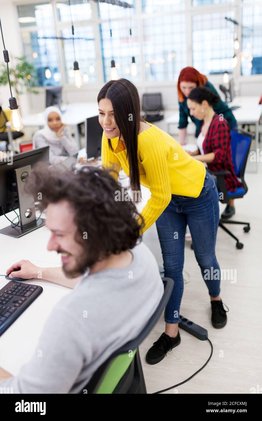 Group of multiethnic colleagues working on desktop computers in a ...