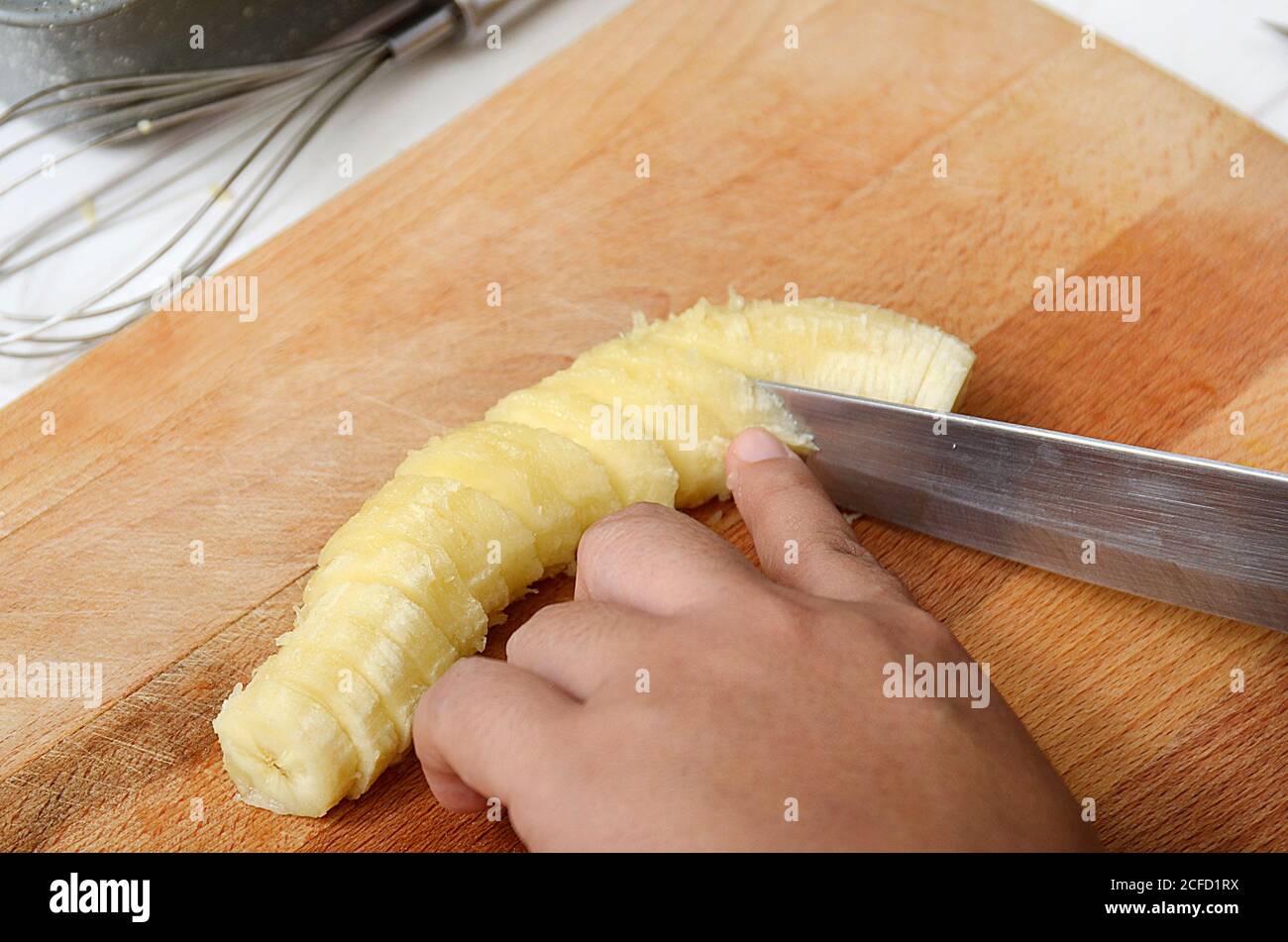 slicing banana on a chopping board Stock Photo - Alamy
