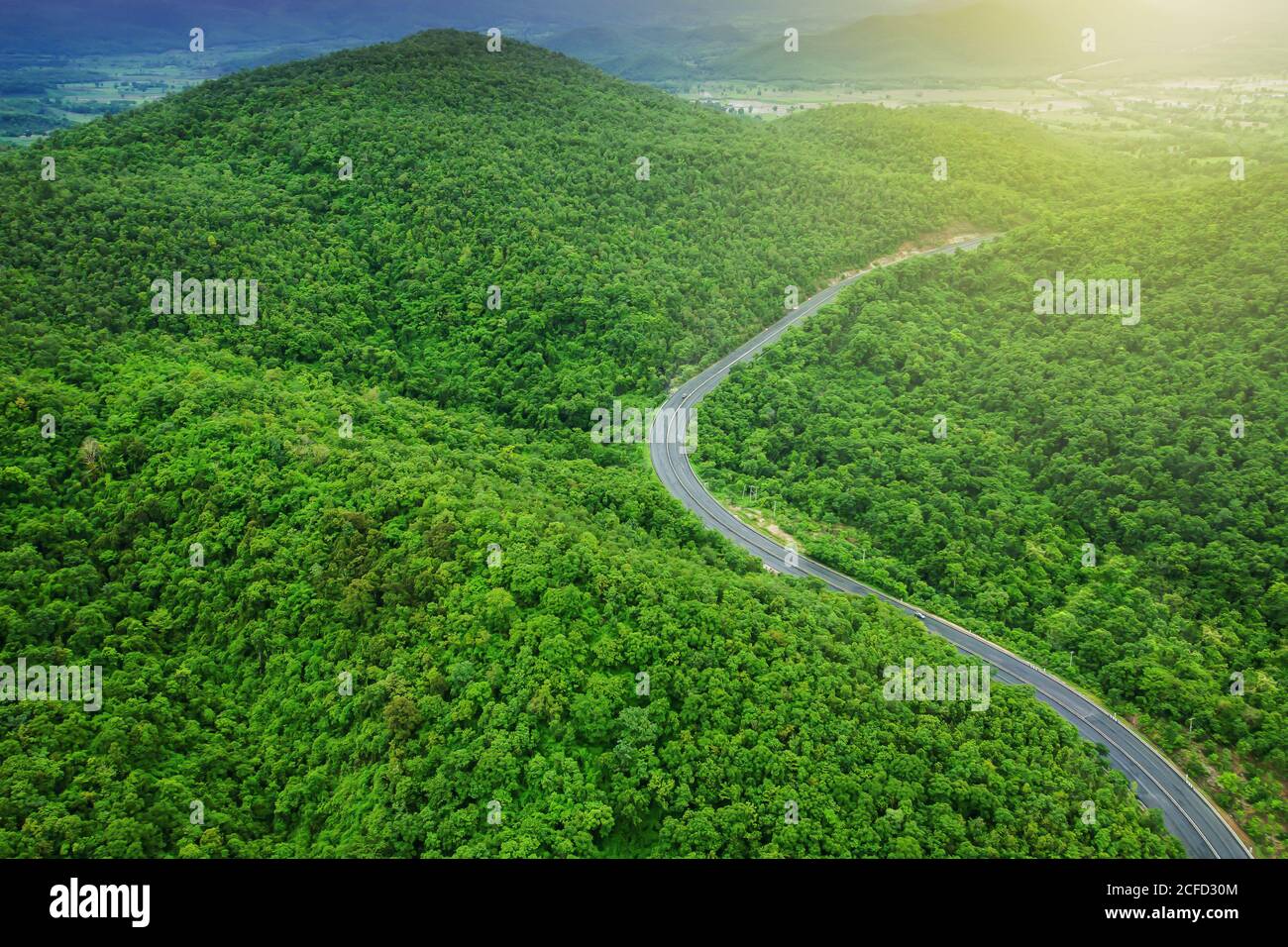 Aerial view of mountain road at sunrise, curves asphalt road through ...
