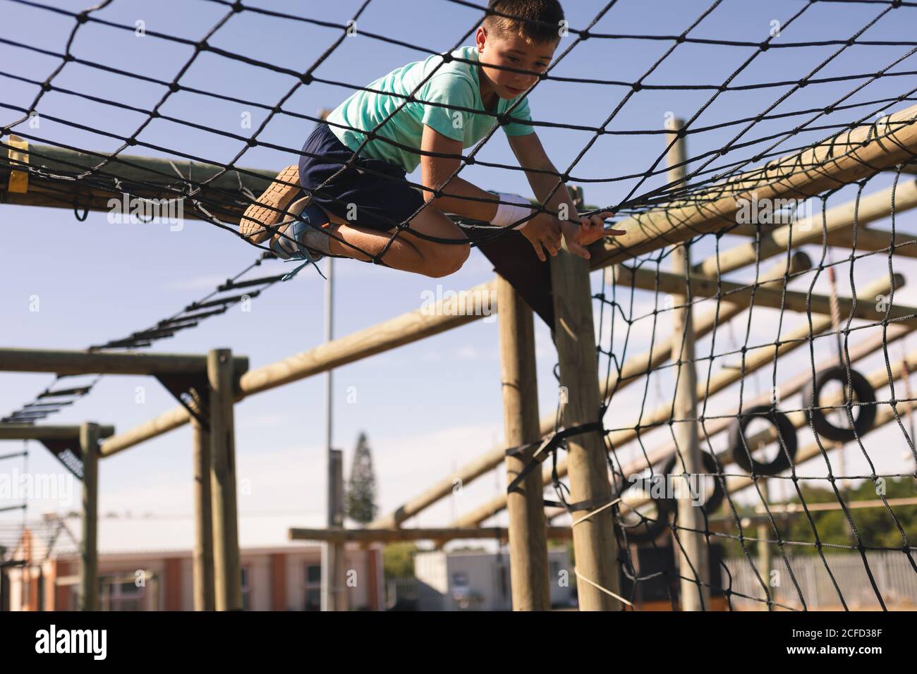 Boy rope climbing during obstacle course at a boot camp Stock Photo - Alamy