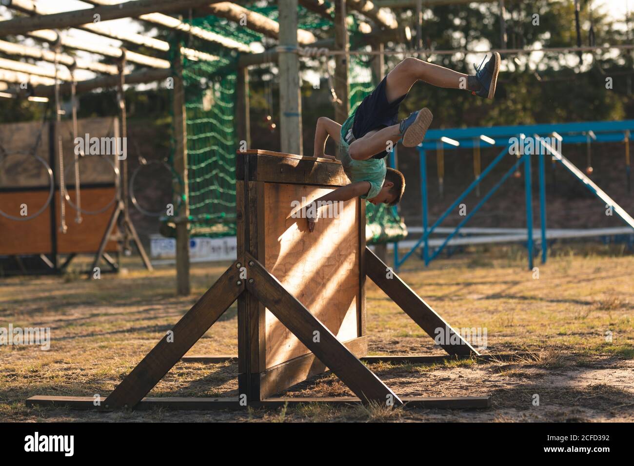 Boy jumping over a hurdle during obstacle course at a boot camp Stock ...