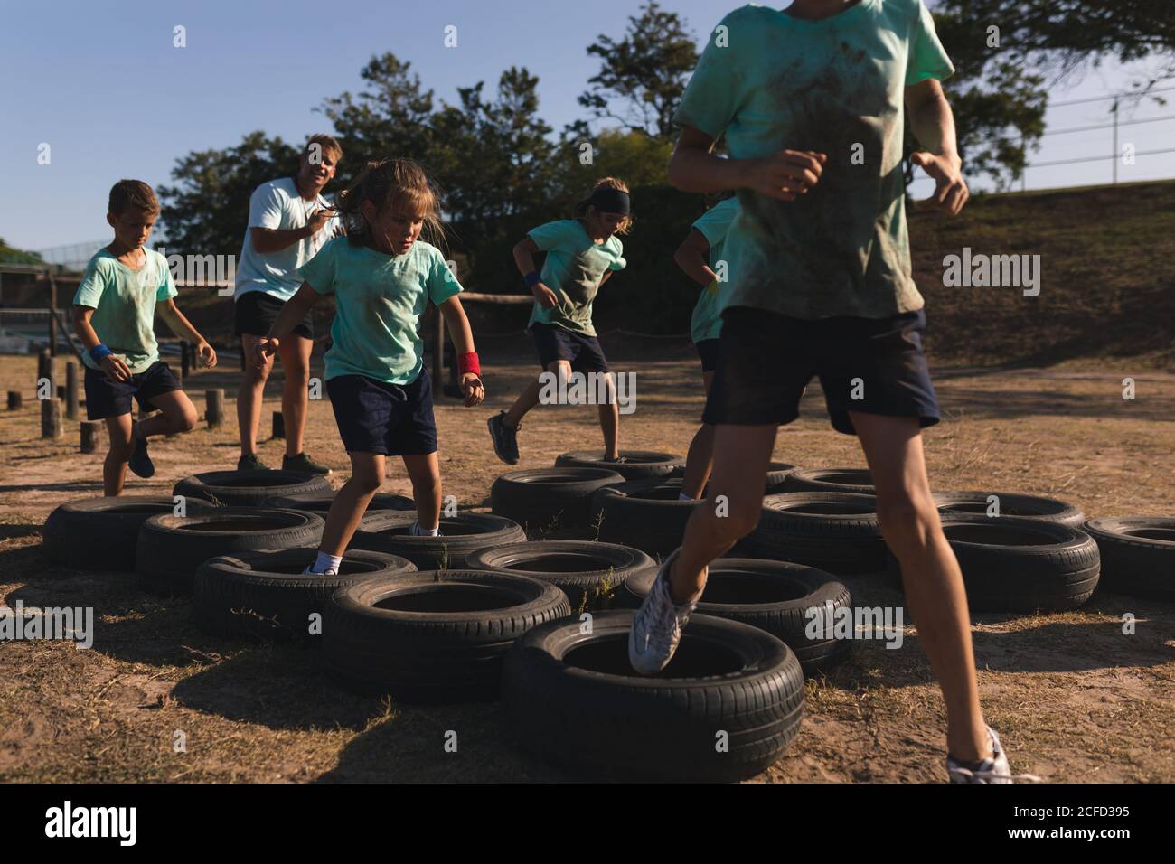 Group of kids walking through tires during obstacle course at a boot ...